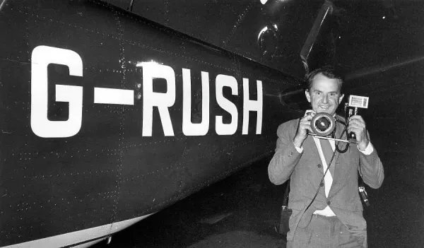 Press photographer at work alongside an aircraft with