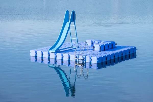 Blue dock with water slide floating in blue lake Our beautiful Wall Art ...